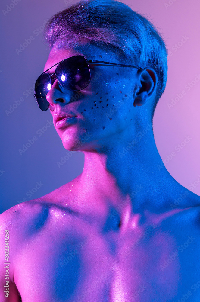 Handsome pumped up guy in black sunglasses. Sports guy, attractive male body. Studio shooting ...
