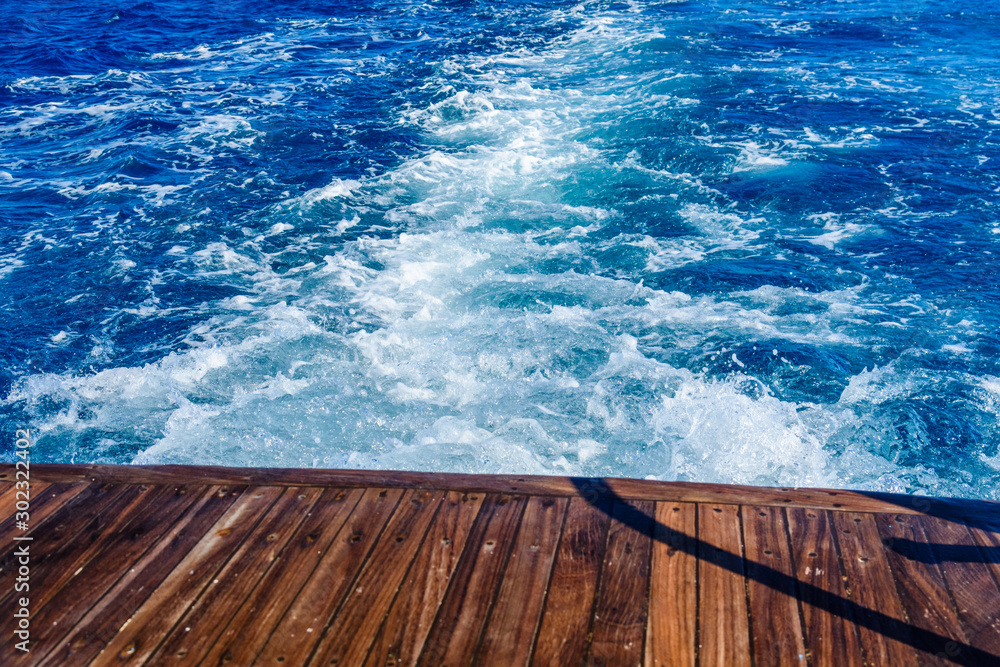 Wave trace with white foam on a water surface behind of fast moving ...