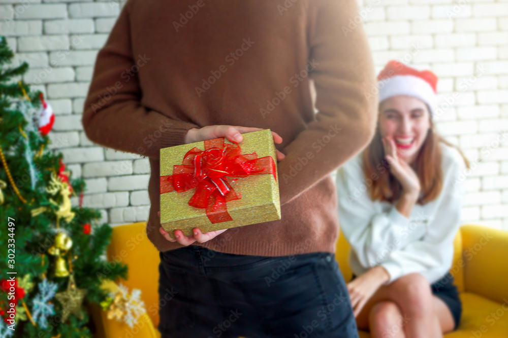 Man hiding a Christmas gift box behind back, ready to give a Christmas ...