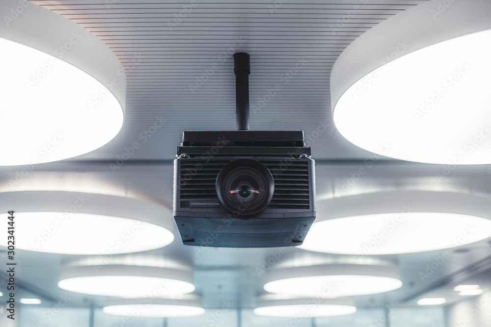 A black modern projector with a plastic case and a huge lens with ...