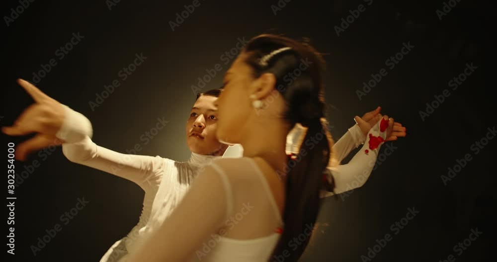 Teen asian kids performing ballroom sport dance on stage with smoked ...