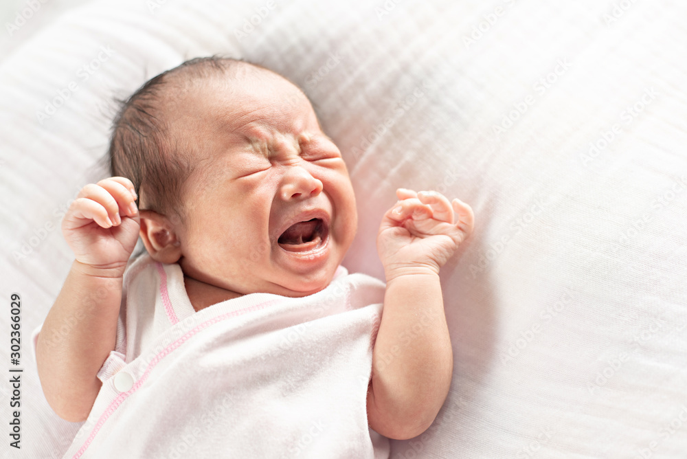 Cute little baby newborn crying lying on bed. Stock Photo | Adobe Stock