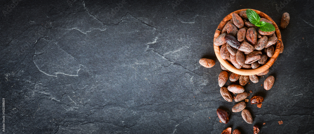 Cocoa beans on dark stone table top view, black background. Cocoas bean ...