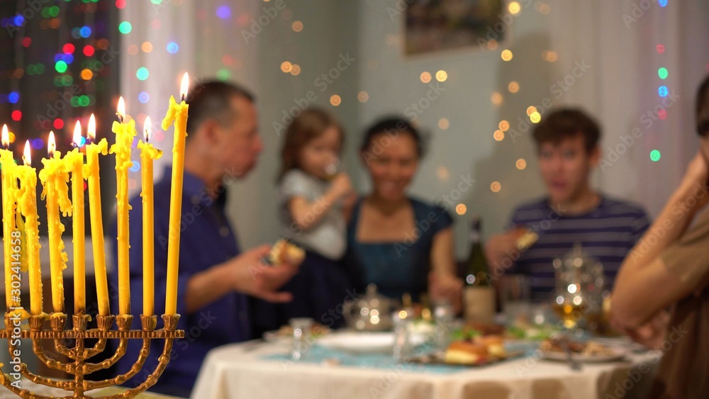 Happy Jewish family celebrates Hanukkah holiday. Hanukkah lights at ...