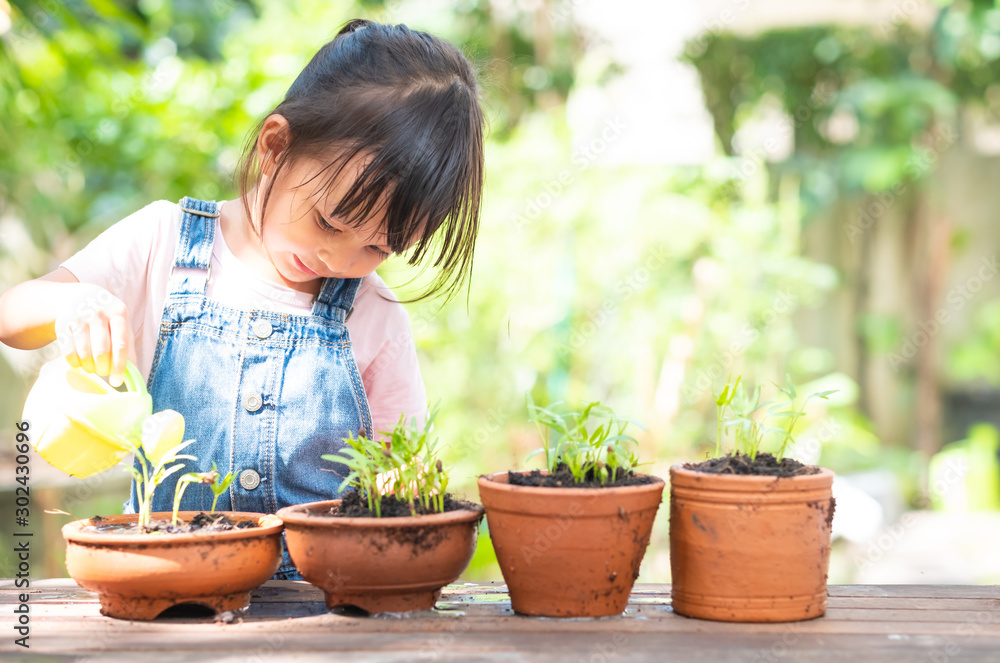 Adorable 3 years old asian little girl is watering the plant in the ...