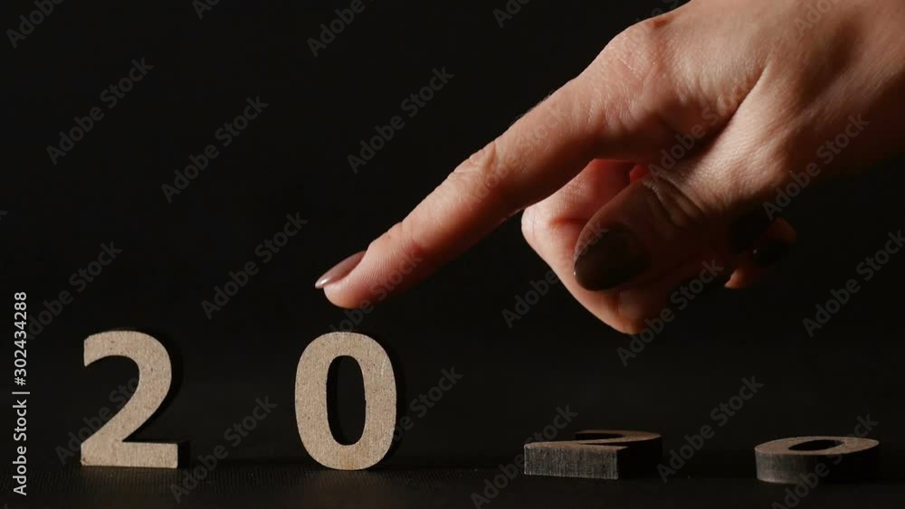 female hand puts numbers 2020 new year instead of the old 2019 by ...