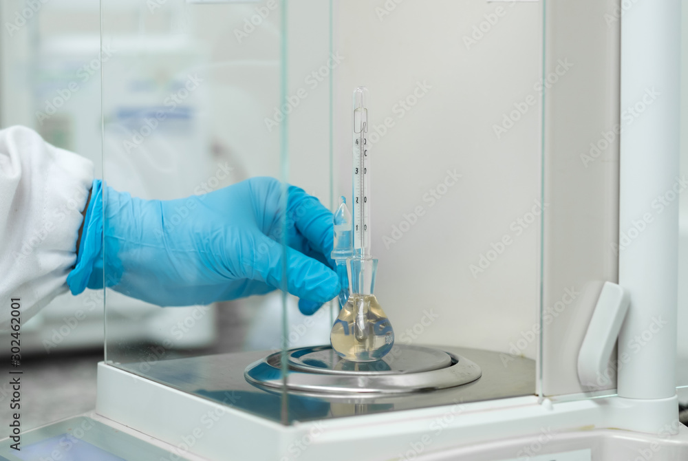 Foto de Analyst is weighing the pycnometer contain liquid sample for ...