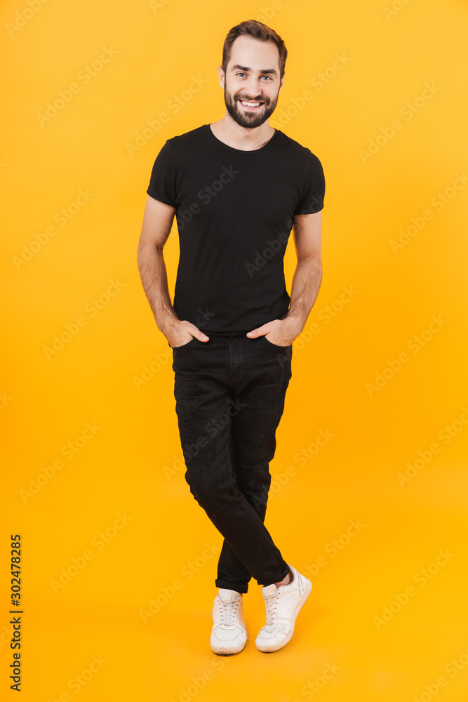 Full length image of happy man in basic clothes smiling at camera Stock ...