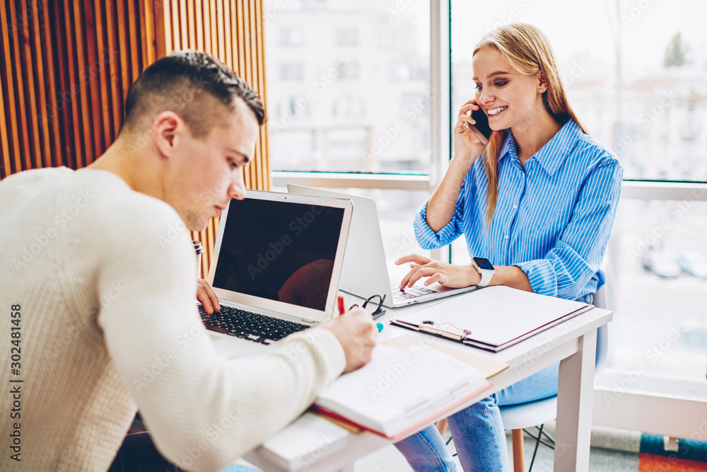 Cheerful female employee making phone call talking about business ...