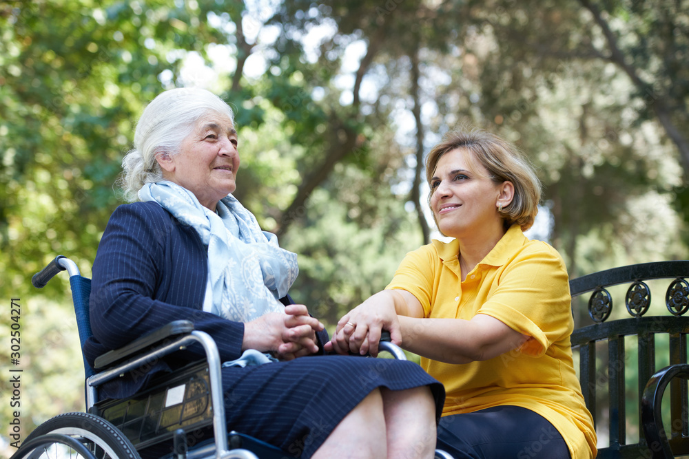 Professional helpful caregiver and handicapped senior woman. Stock ...