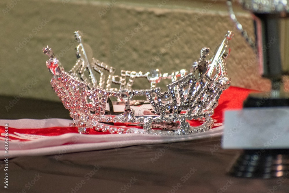 A lone tiara, sash, and trophy sit to be presented to the winner. Stock ...