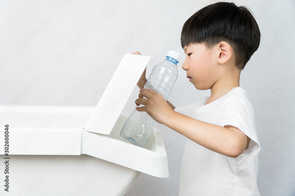 Portrait, Cute little Asian boy throw plastic bottle into sorting bins ...