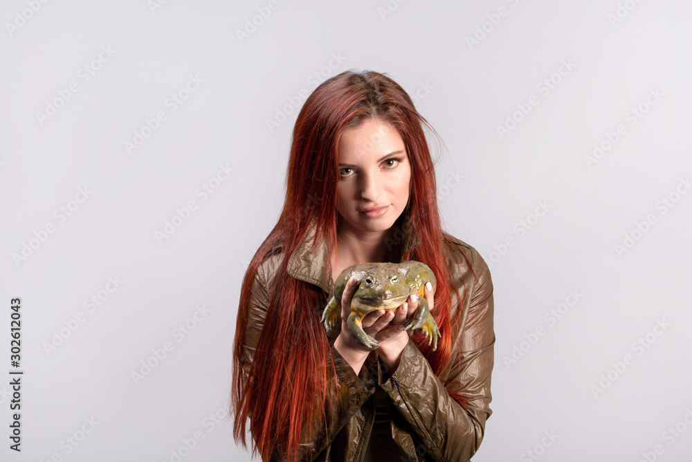 Princess and the Frog. pretty redhead woman with big frog in her hand ...