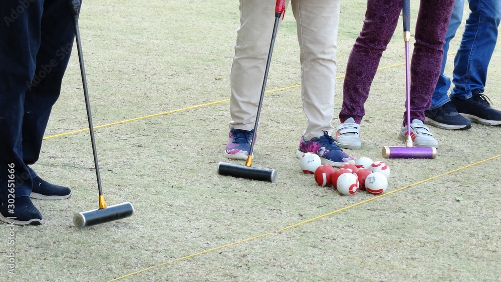 People are playing gate ball in the field in the morning. Gateball is a ...