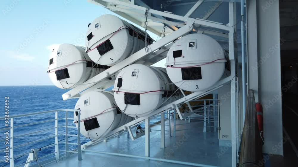 Inflatable life rafts secured on side of cruise ship in storage rack ...