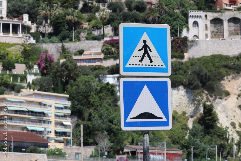 Pedestrian crossing and speed bump sign traffic signs on the street ...