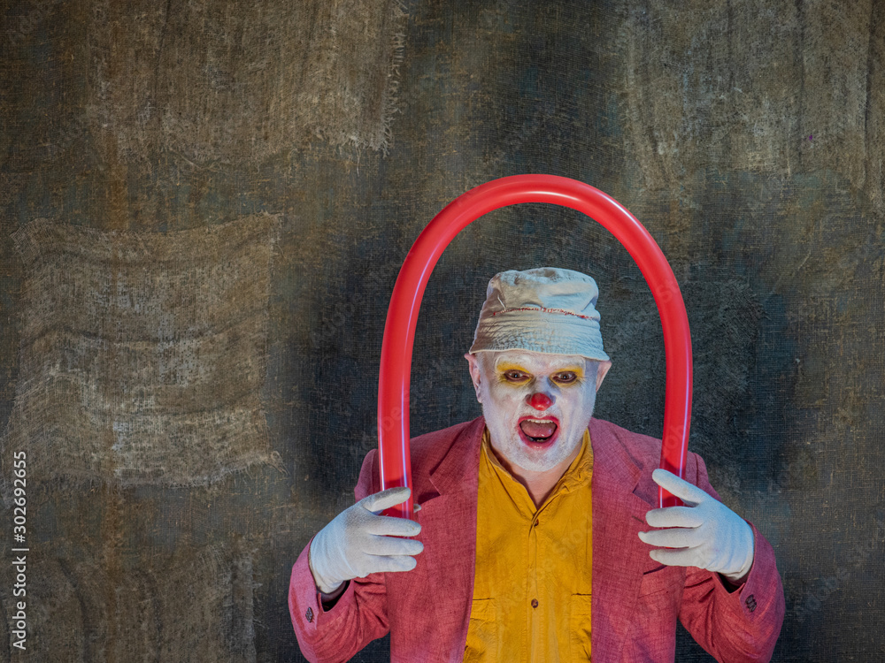 Crazy aggressive clown with red ball and shadow. man hates his work and ...