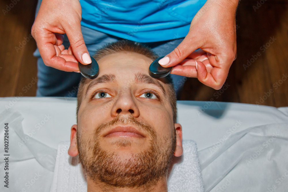 Wellness concept. Handsome young man relaxing under the stimulating ...