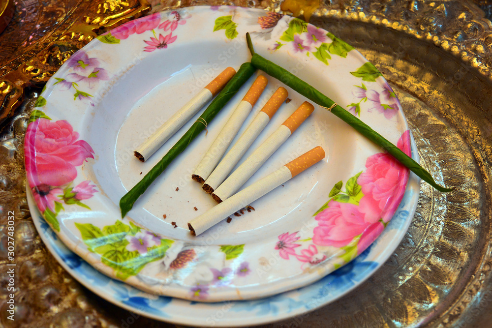 Cigarettes and bidis on a plate for a Buddhist funeral ritual Stock ...