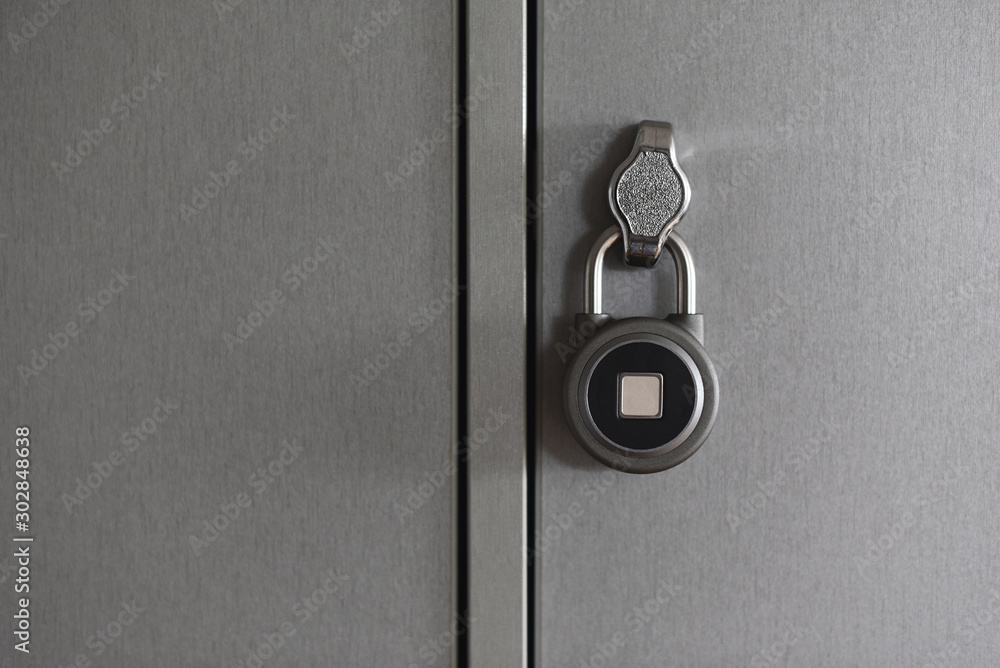 fingerprint padlock is locked and hanging on cell of storage locker in ...
