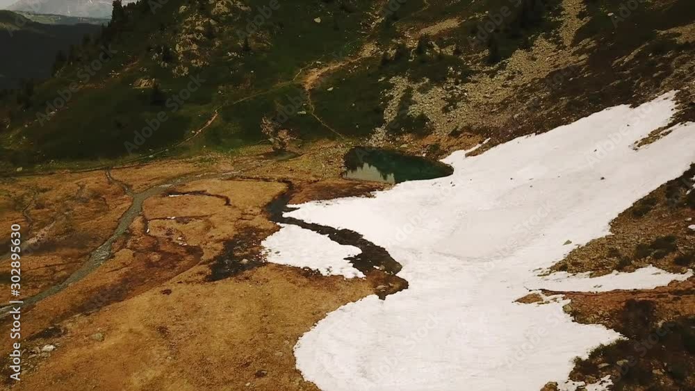 Aerial tracking shot of wild mountain landscape with little lake Stock ...