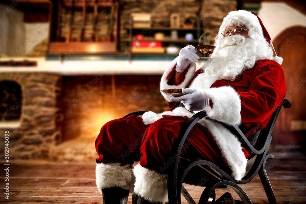 Red old Santa Claus in rocking chair.Fireplace in home interior.Copy ...