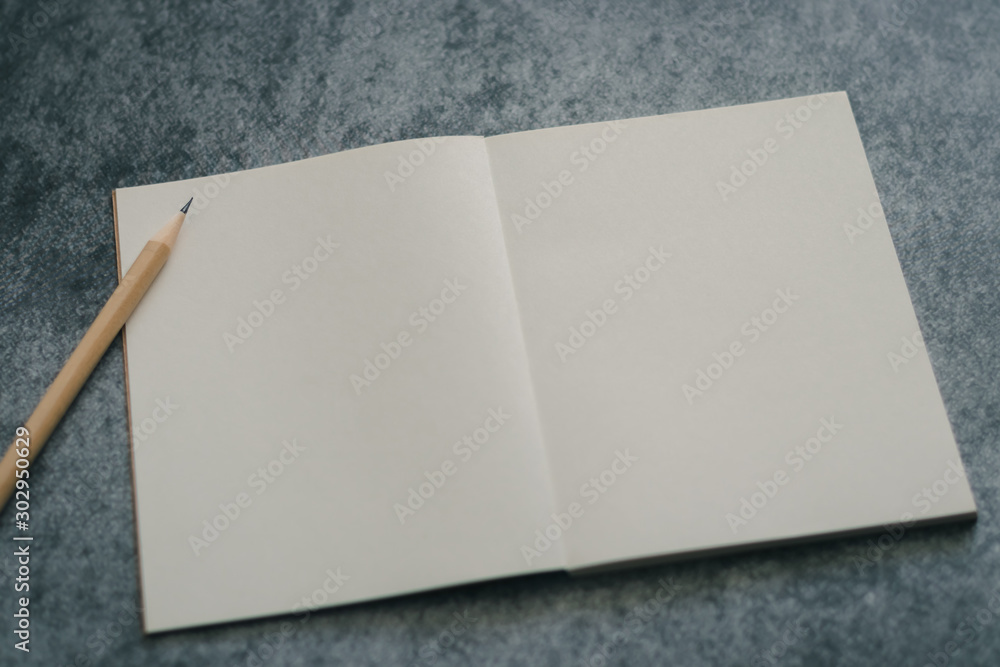 Sharp pencil and plain notebook on black background with copy space ...