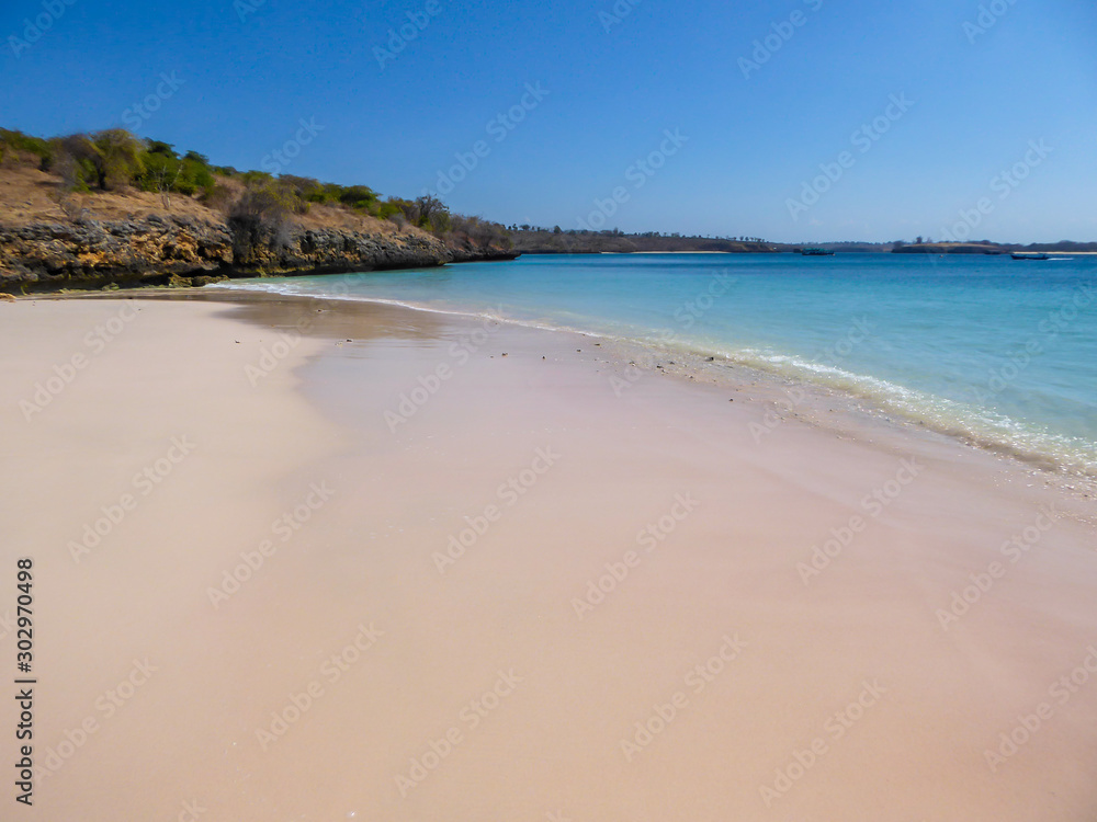 An idyllic Pink Beach on Lombok, Indonesia. Sea is calm, shining with ...