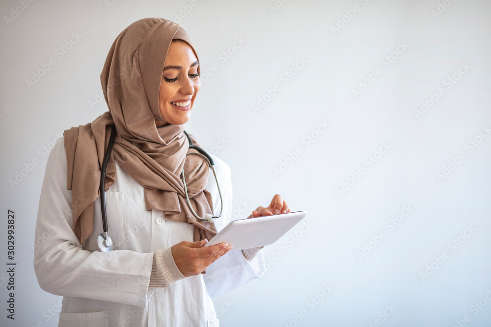 Muslimah doctor with stethoscope holding a tablet computer isolated in ...
