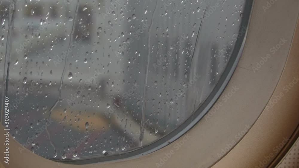 Water drops and streams on porthole of an airplane delayed due to ...