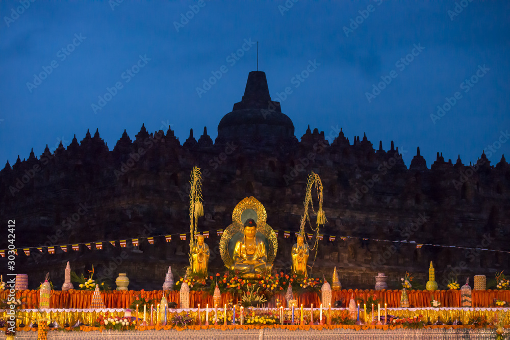 Golden Waisak (Vesak) altar in front of Borobudur Temple silhouette and ...