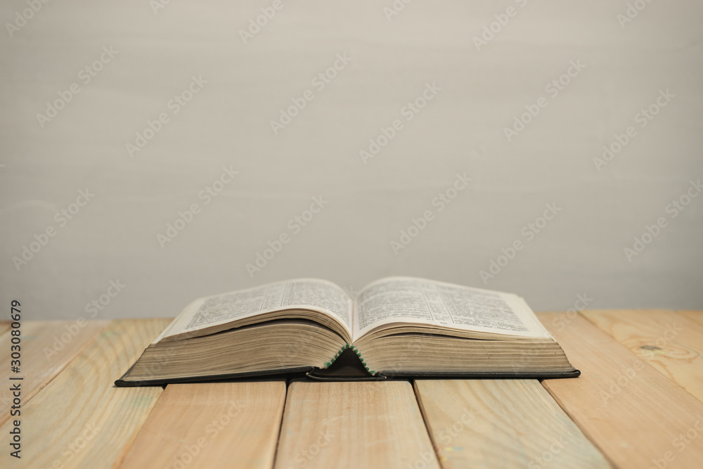 Open Bible on a old wooden table and white wall background. Religion ...
