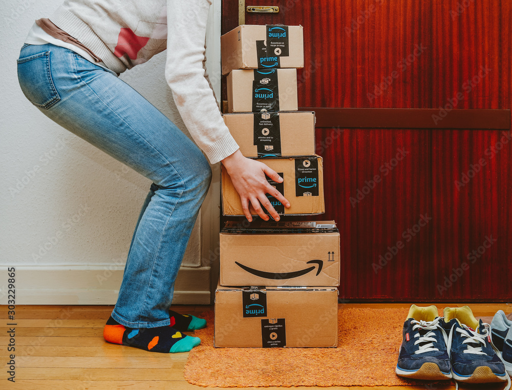 PARIS, FRANCE - JAN 13, 2018: Woman lifting heavy stack of Amazon Prime ...