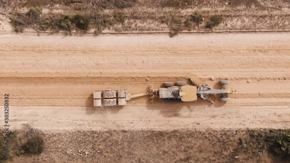 Top down aerial footage of a motor grader building a new road. Process ...