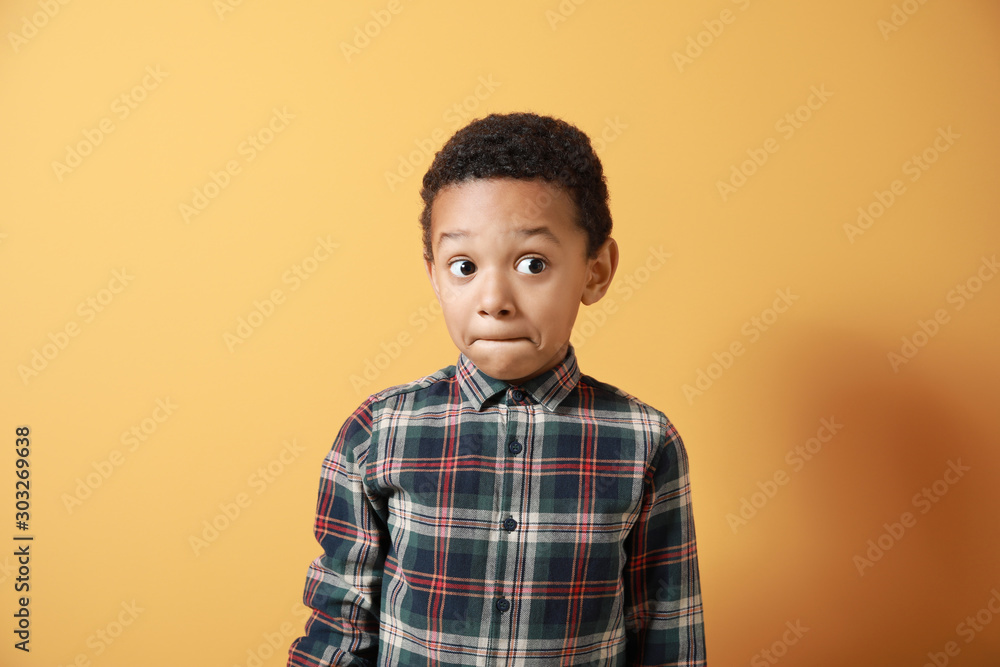Confused African-American boy on color background Stock Photo | Adobe Stock