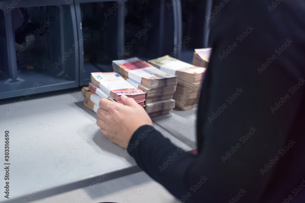 Bank employees sorting and counting money inside bank vault. Large ...