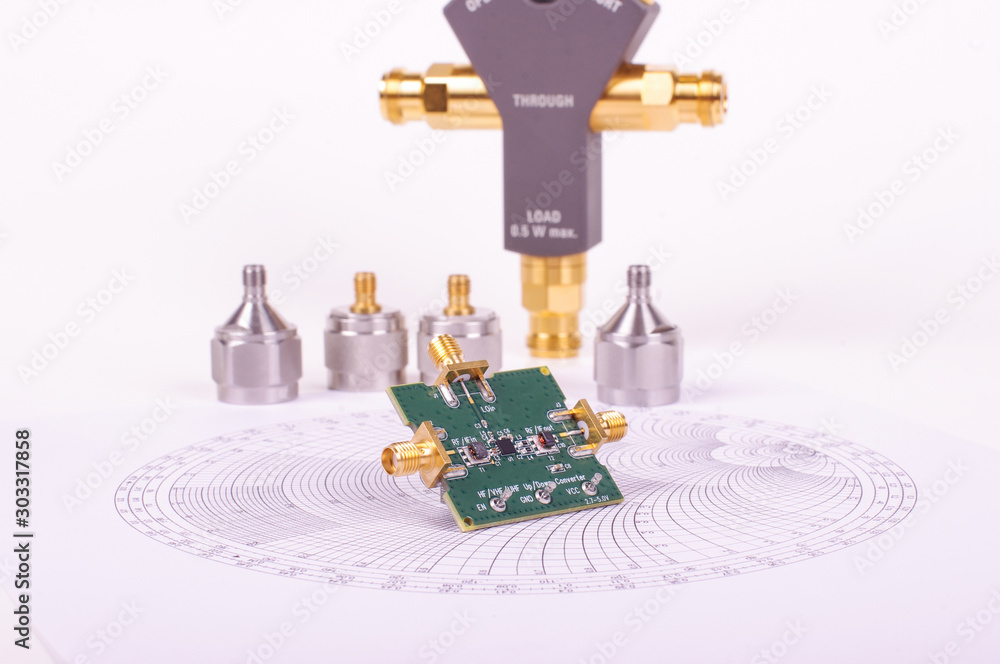 RF mixer electronics PCB in front of Smith chart and other microwave ...