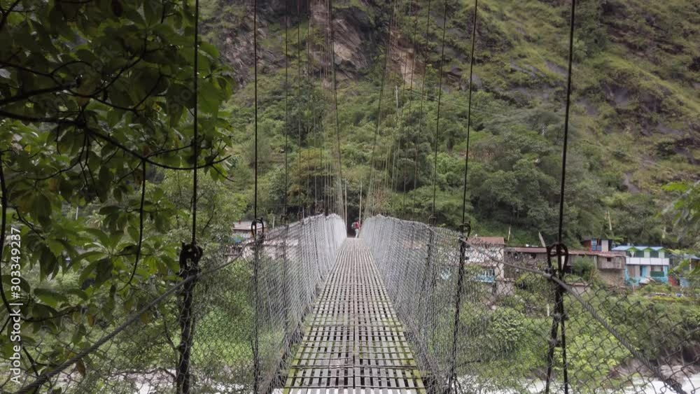 cross a suspension bridge in the himalaya famous trekking annapurna ...