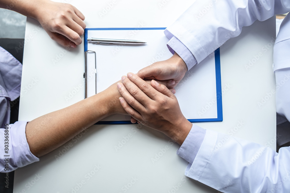 Hand of doctor touching patient reassuring for encouragement and ...