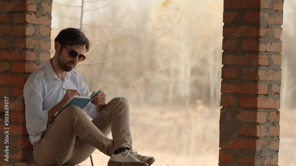 Stockvideon Man Writing Notes In Notebook Outdoors.Man Sitting On Bench ...