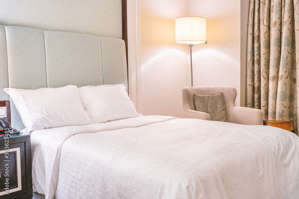 Clean and cozy modern hotel bedroom interior, warm tone room with a ...