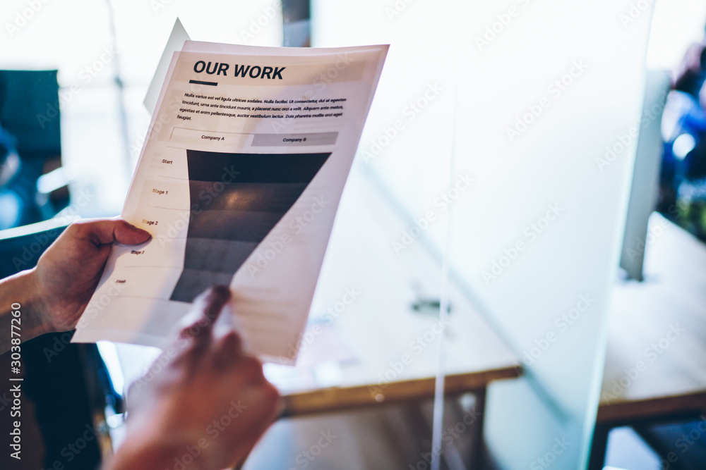 Cropped view of male hands holding printed paper sketch with ...