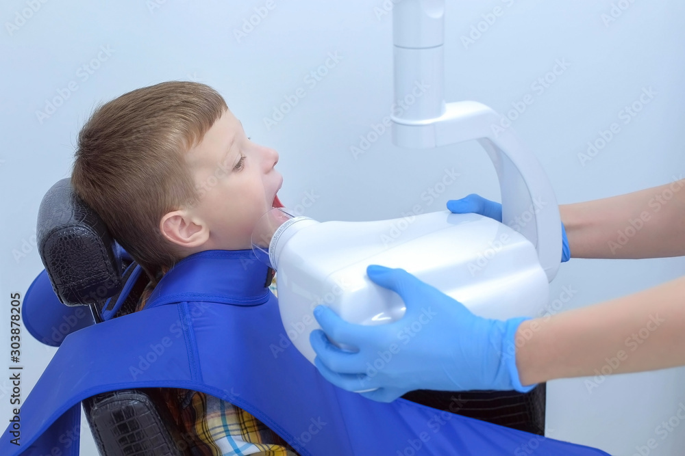 Making x-ray of teeth for teenage boy in dentistry clinic, side view ...