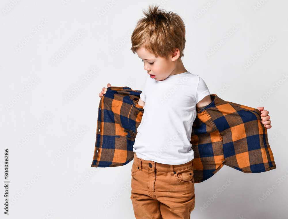 Kid boy in white t-shirt and jeans is holding opened taking off his ...