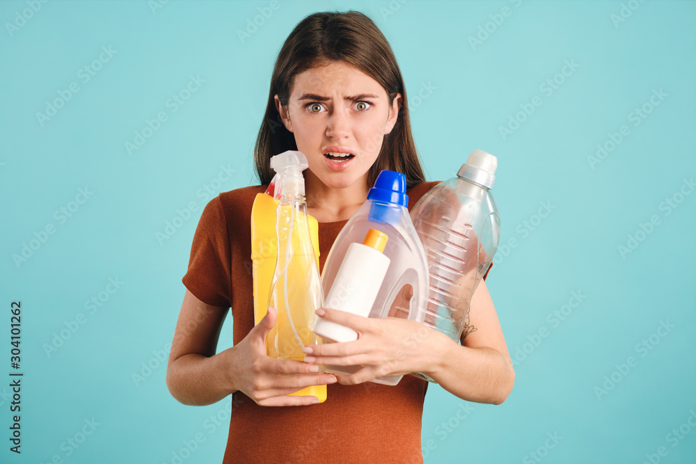Shocked casual girl holding plastic waste in hands while amazedly ...