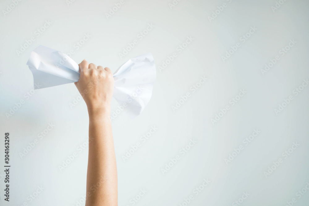 Back of the hand that crushing the white paper and lift it up on white ...