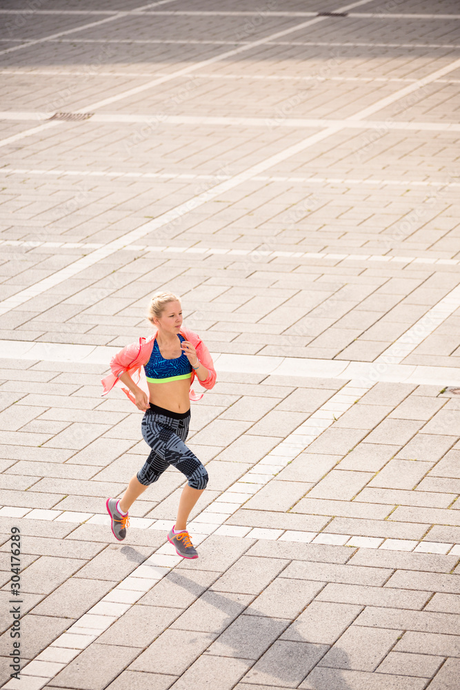 European Quarter, Stuttgart, Baden-W¸rttemberg, Germany: A female runner crossing a public open ...