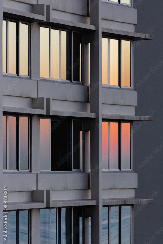 Rich colours of the setting sun reflected off the windows of a gritty ...