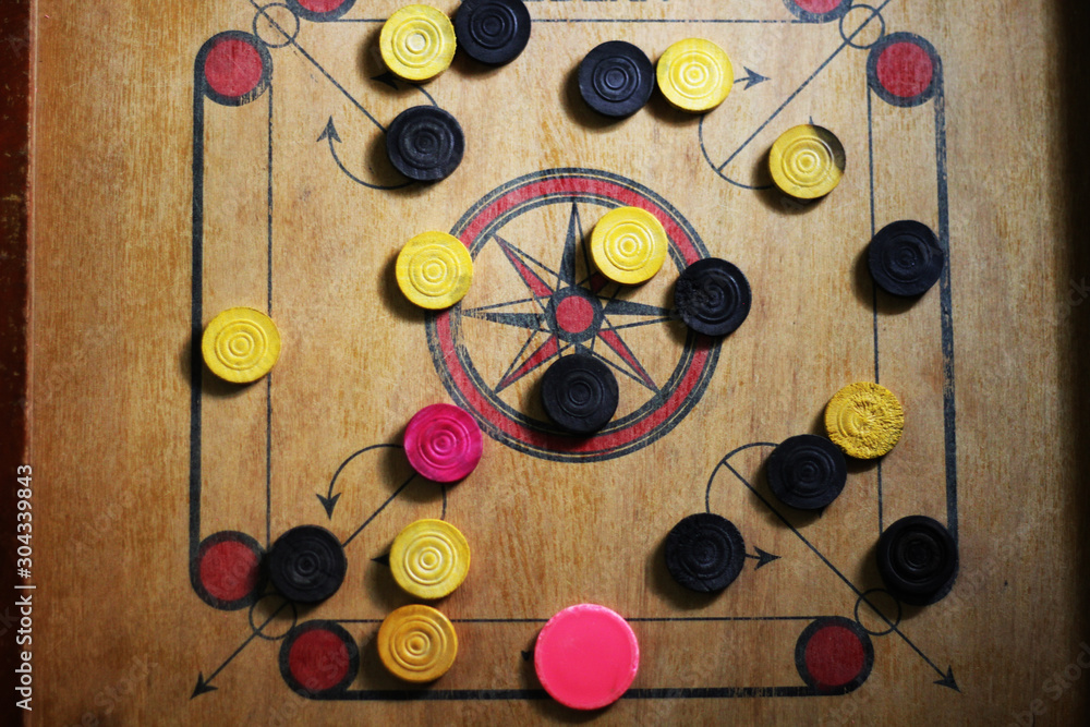 A game of carrom with pieces carrom man on the board carom - stacking.A ...