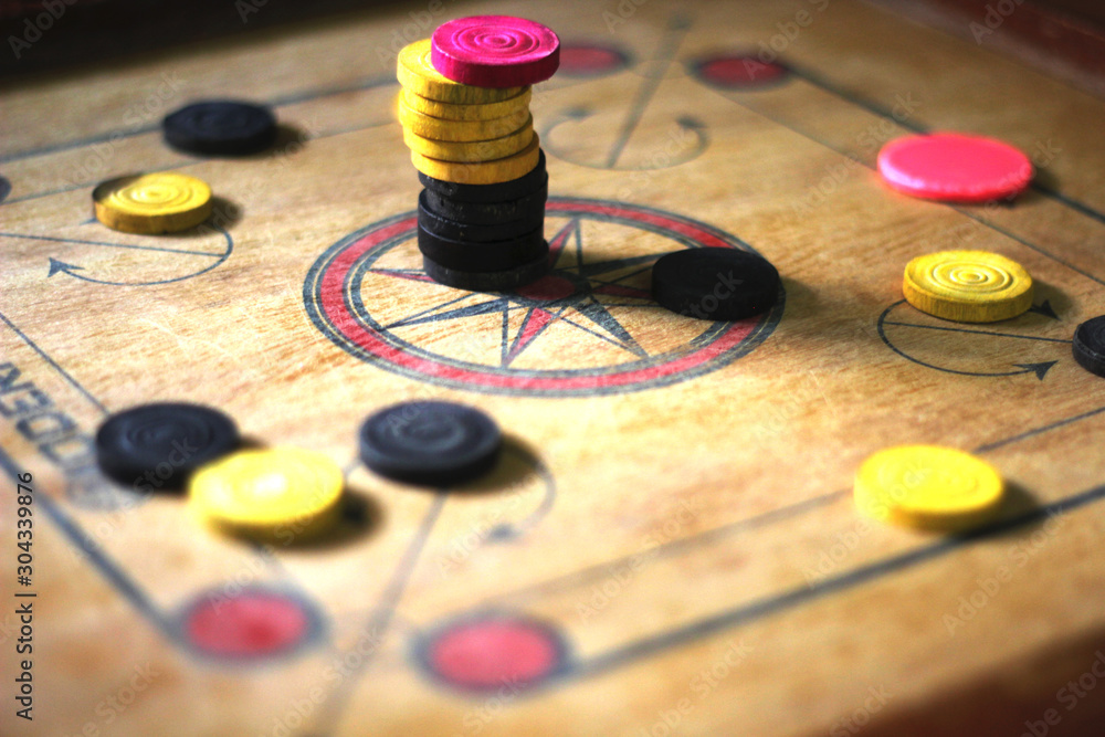 A game of carrom with pieces carrom man on the board carom - stacking.A ...